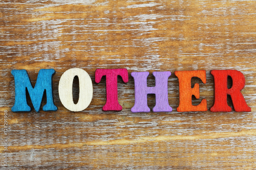 Word mother written with colorful letters on rustic wooden surface ...