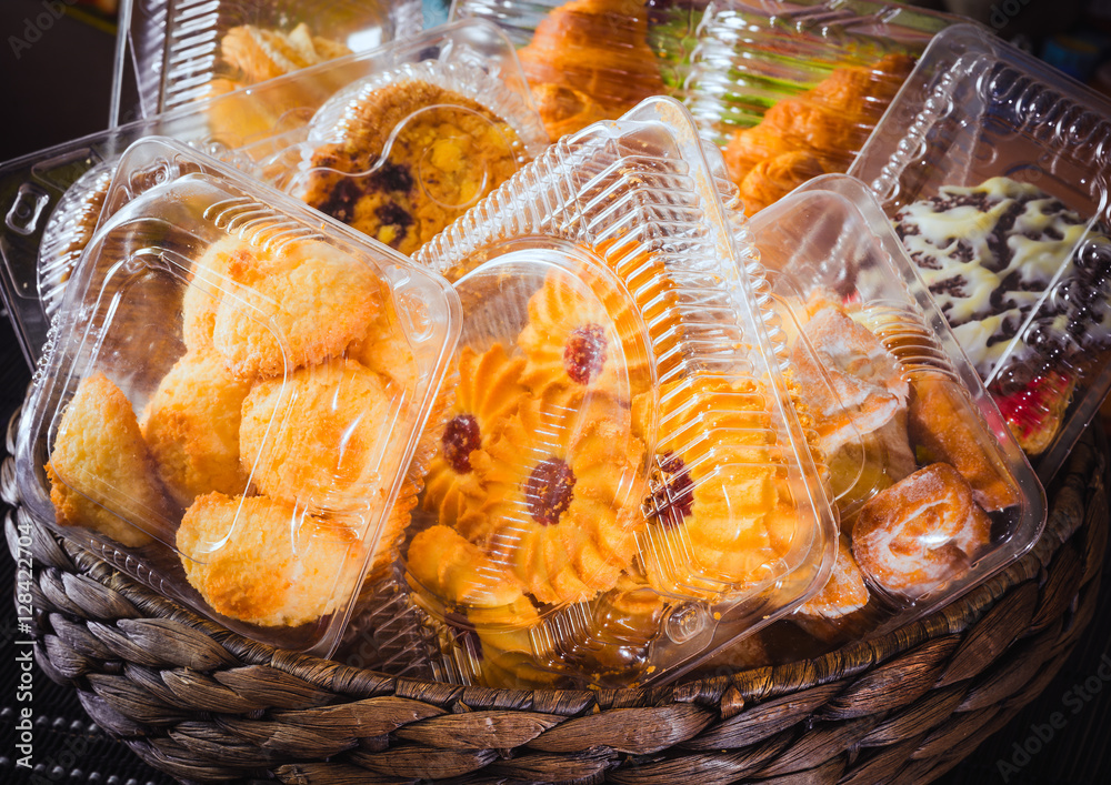 Plastic disposable containers with cookies and pastries in a wicker ...