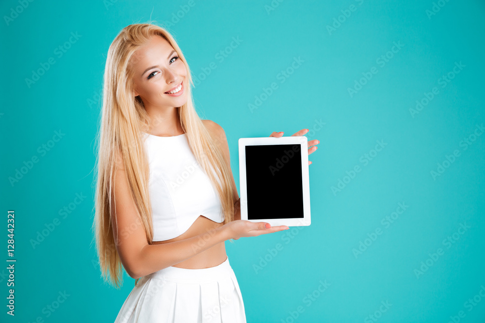 Happy blonde woman standing and showing blank screen tablet Stock Photo ...
