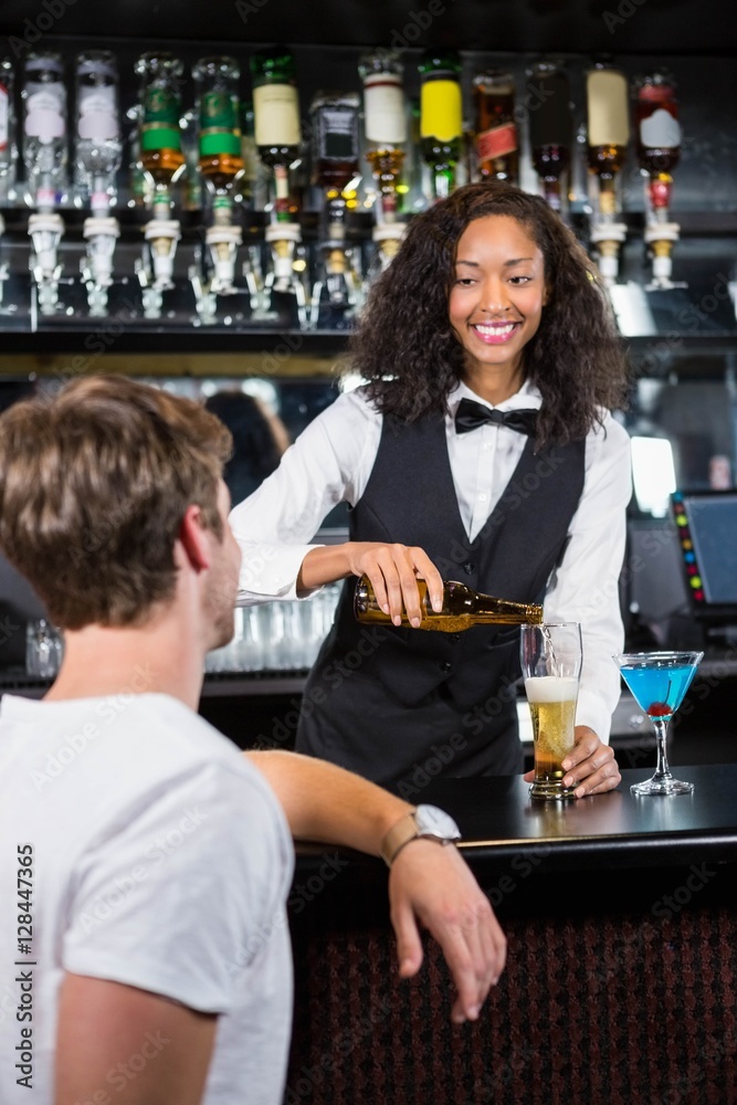 Beautiful barmaid pouring beer in glass 스톡 사진 | Adobe Stock