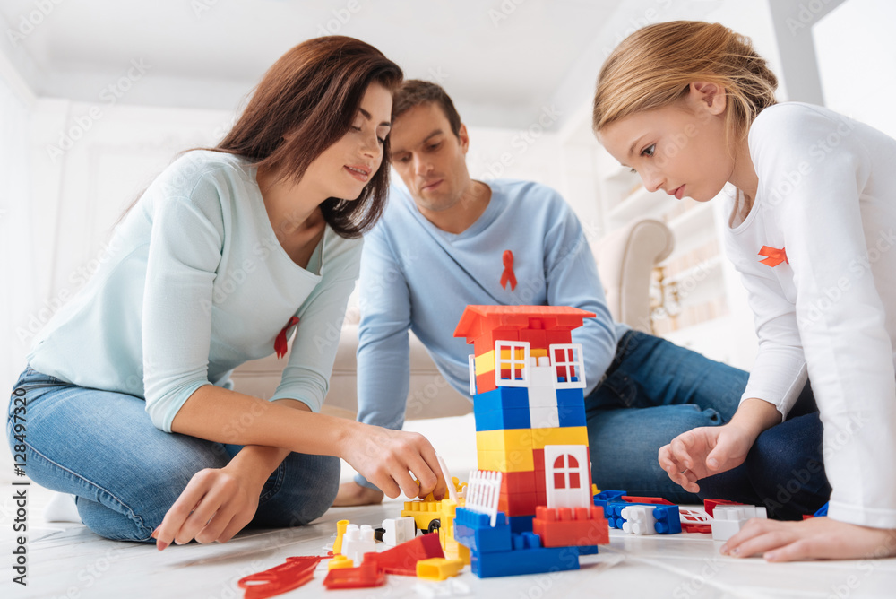 Serious thoughtful family building a toy construction Stock Photo ...