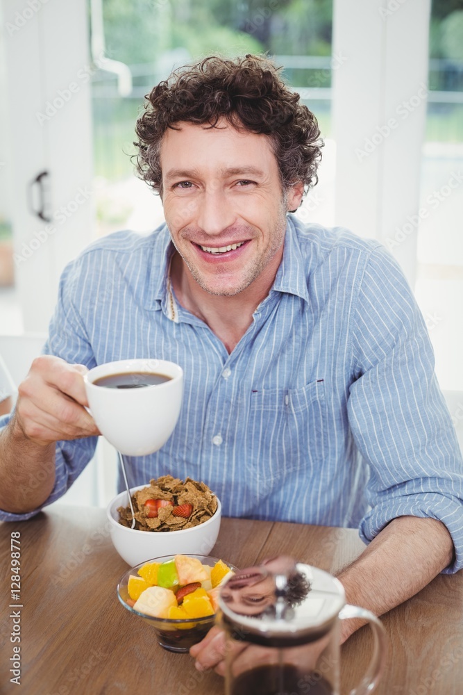 Happy man drinking tea by table Stock Photo | Adobe Stock