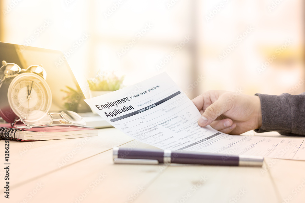 Businessman or job seeker fill in Employment Application form with pen ...