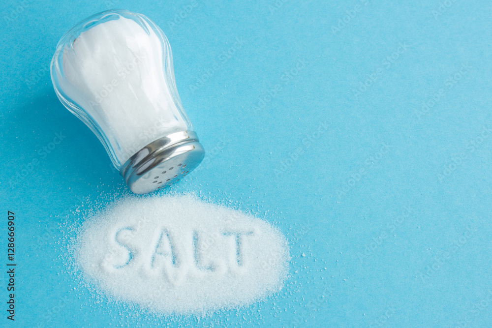 Word salt written in salt. Lettering. Crumbled salt on a blue ba Stock ...