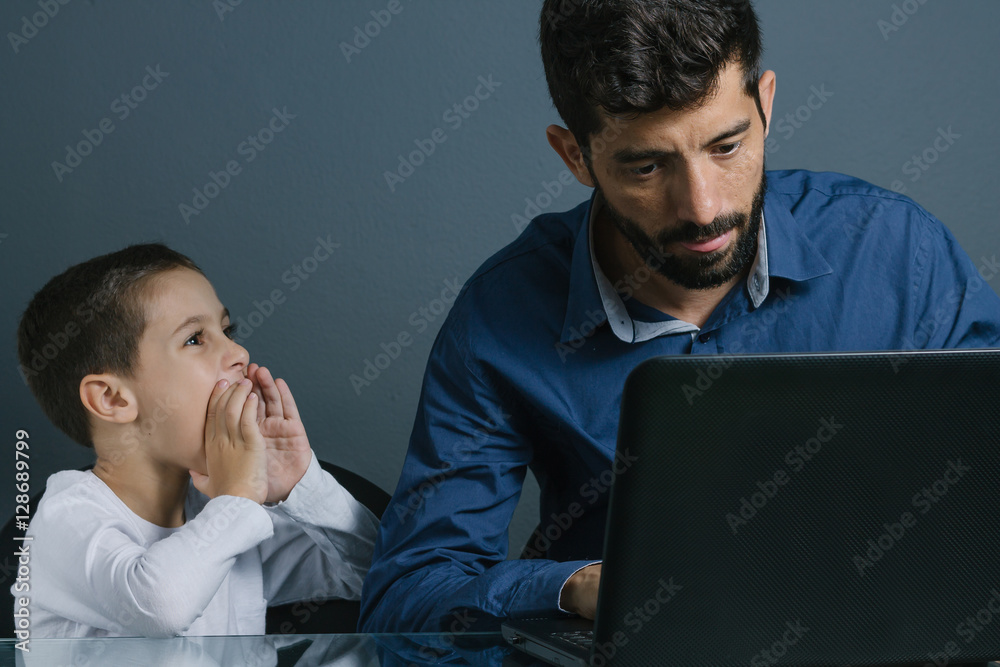 Father on laptop ignoring son while the child tries to catch his ...