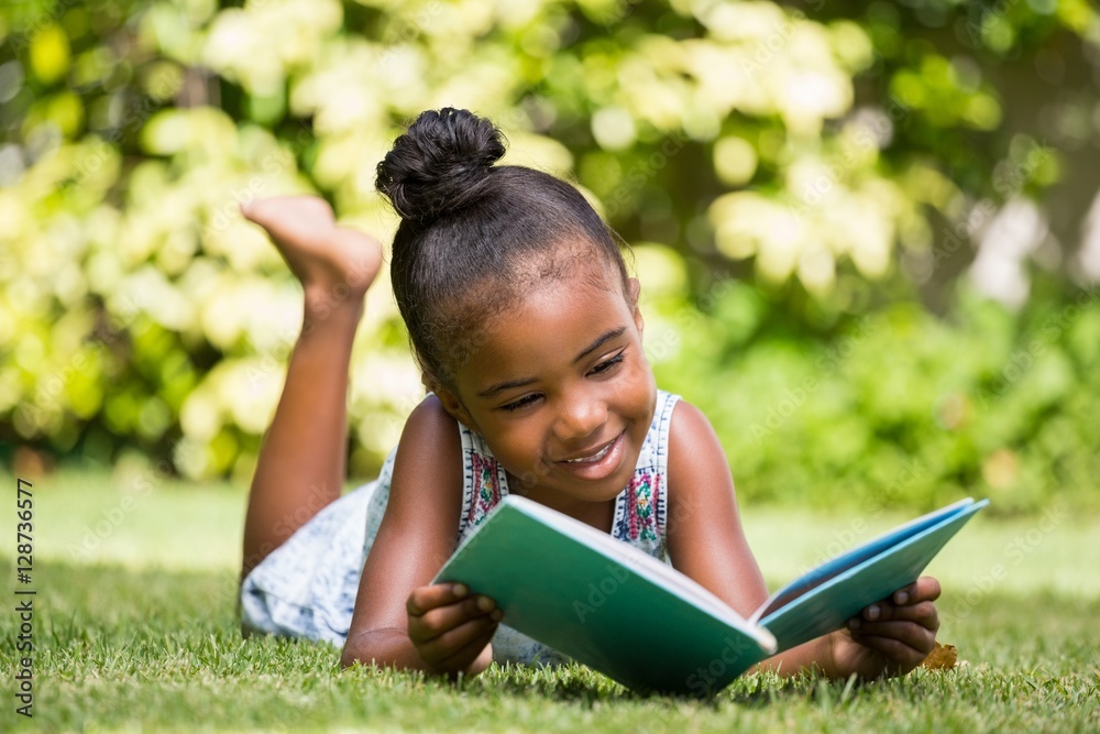 Little girl reading a book at park Stock Photo | Adobe Stock
