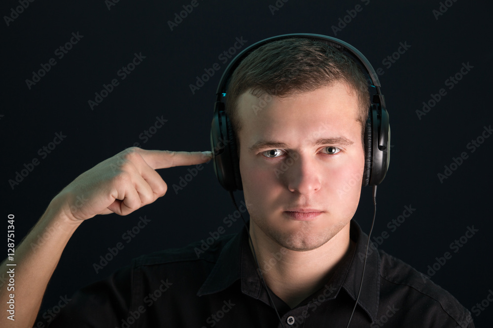Portrait of young guy with headphones on the dark background Stock ...