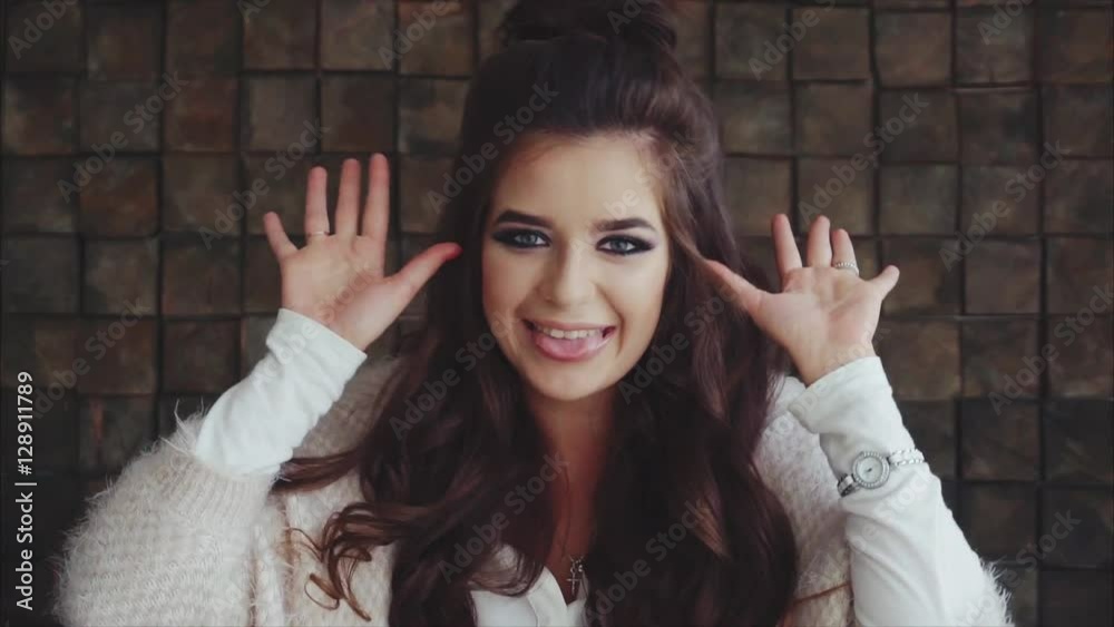 Pretty woman brunette looking to the camera, laughing and making funny ...