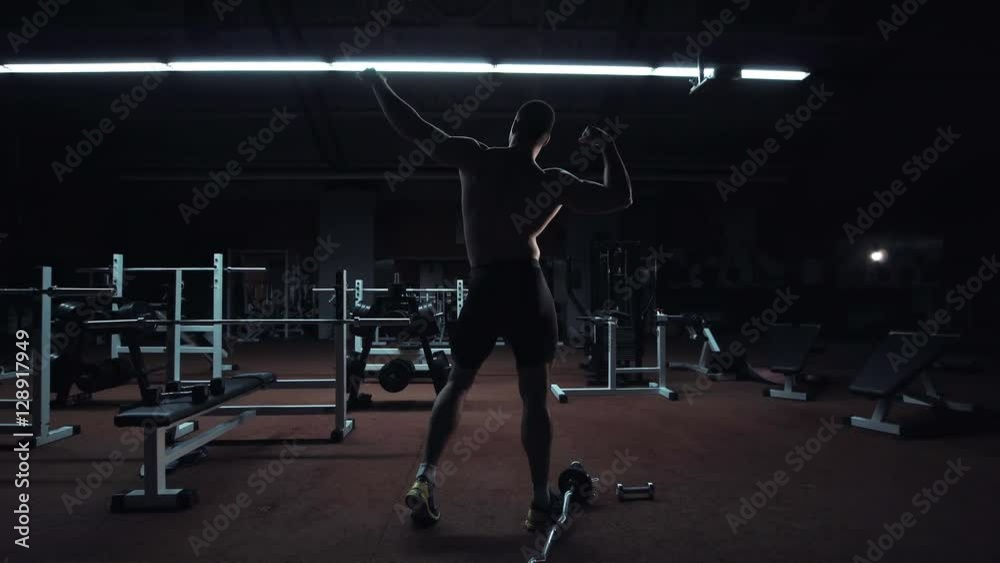 Strong muscular bodybuilder showing off his physique standing with his ...