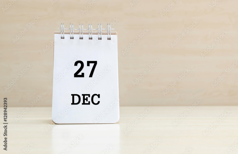 Closeup surface note book with black 27 dec word in page on blurred ...
