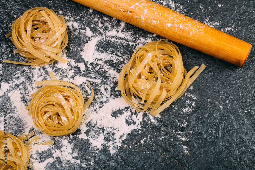 Uncooked rolled traditional italian pasta on wooden background ...