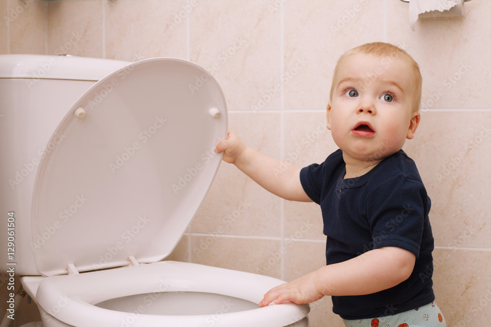 little boy looks in the toilet Stock Photo | Adobe Stock