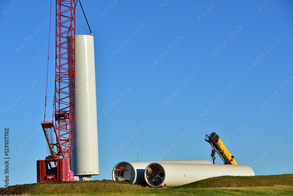 Installing base section of tower for wind turbine as part of wind farm ...
