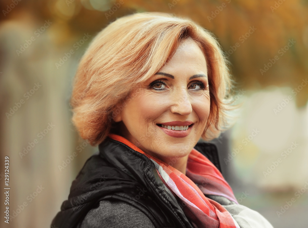 Closeup portrait of gorgeous middle aged woman on blurred background ...