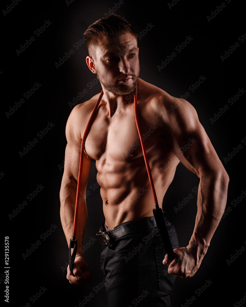 Bodybuilder posing on a black background. Dramatic portrait of an ...