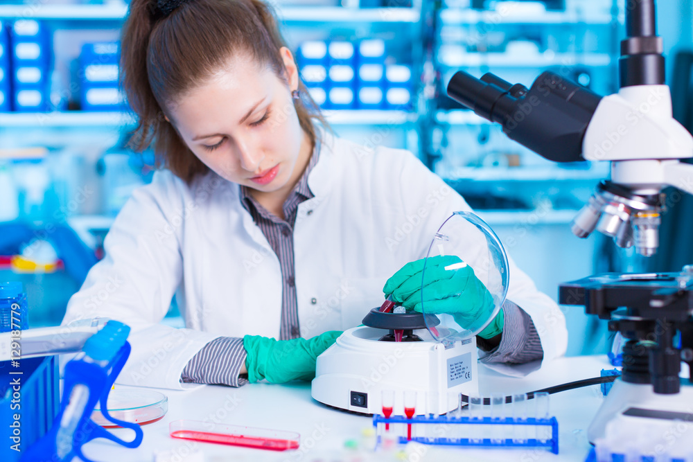 woman in a laboratory with microtube test tube in hand and PCR ...
