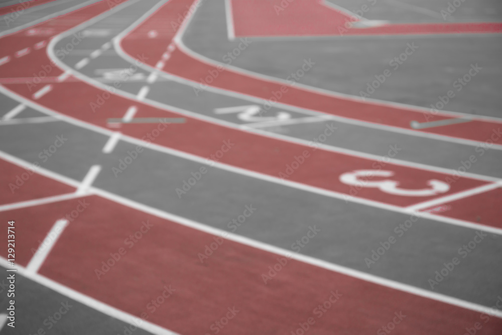 Blurred image of running track with numbers from 1 to 3. Red color ...