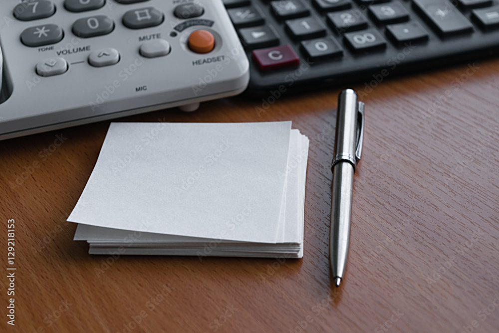 telephone, calculator, white paper for notes and metal ballpoint pen ...