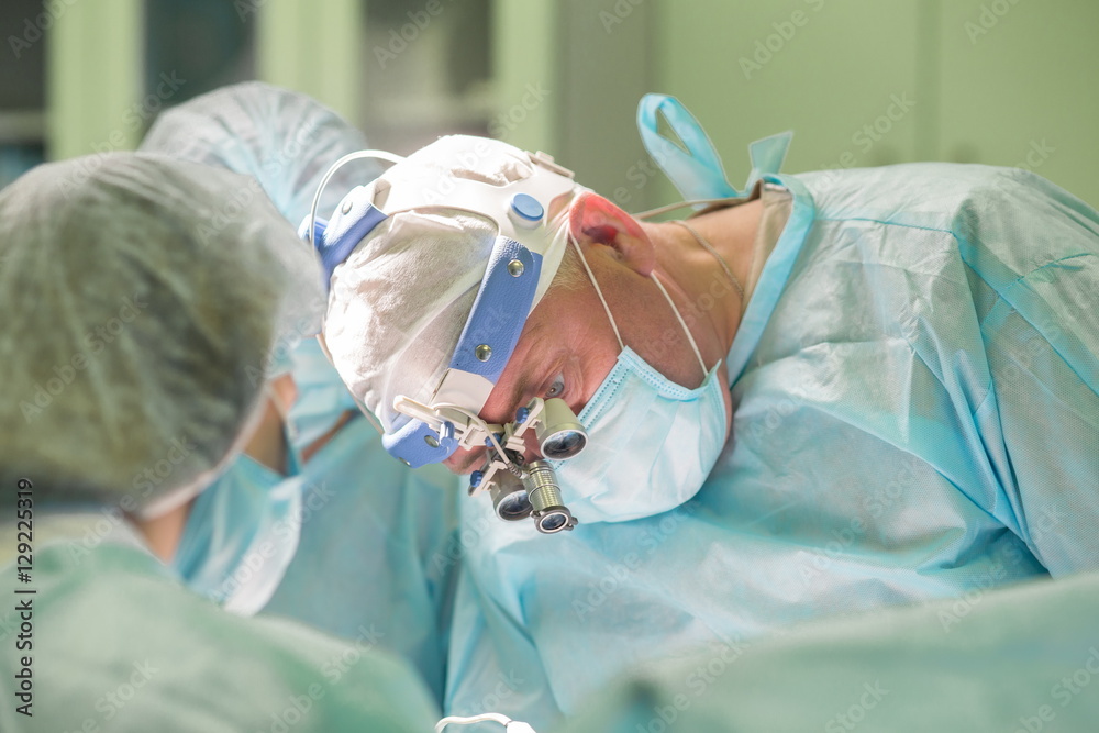 Surgeon performing cosmetic surgery on breasts in hospital operating ...