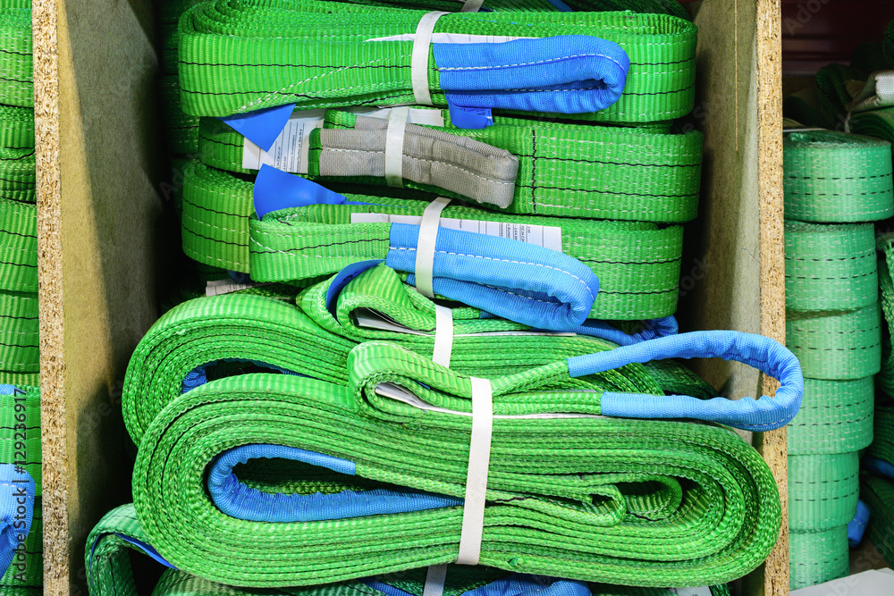 Green nylon soft lifting slings stacked in piles. Stock Photo | Adobe Stock