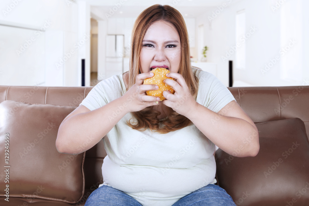Greedy woman eats hamburger Stock Photo | Adobe Stock