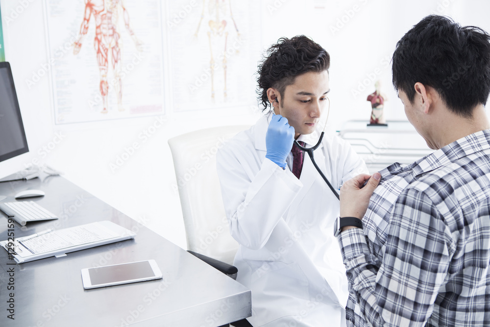 The doctor is diagnosing the patient with a stethoscope Stock Photo ...