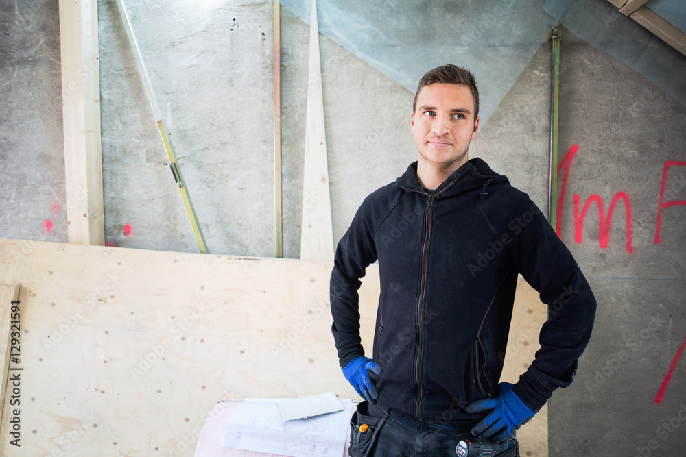 Manual worker standing with hands on hip at construction site Stock ...