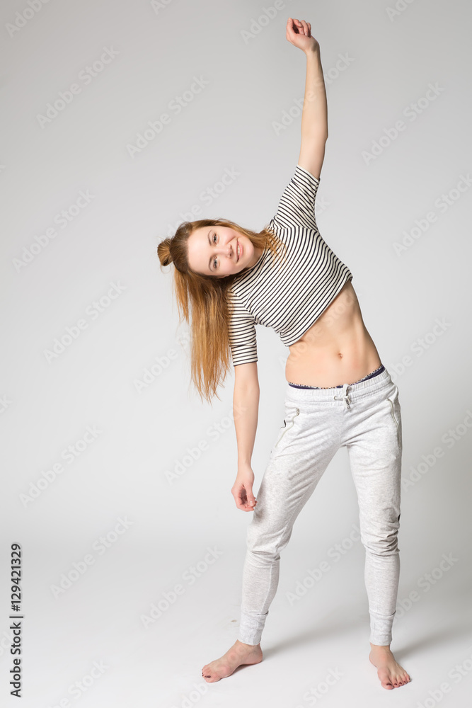 girl is leaning to the side, one hand up the other down. studio shot on ...