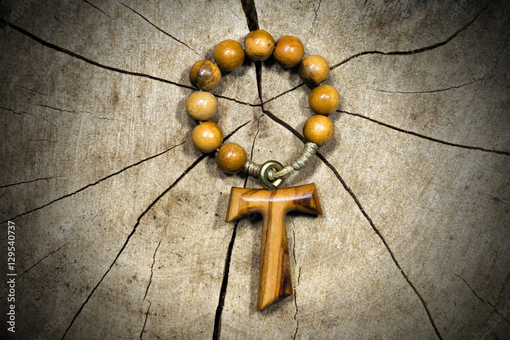 Tau, wooden cross symbol of St. Francis of Assisi with rosary bead on a ...