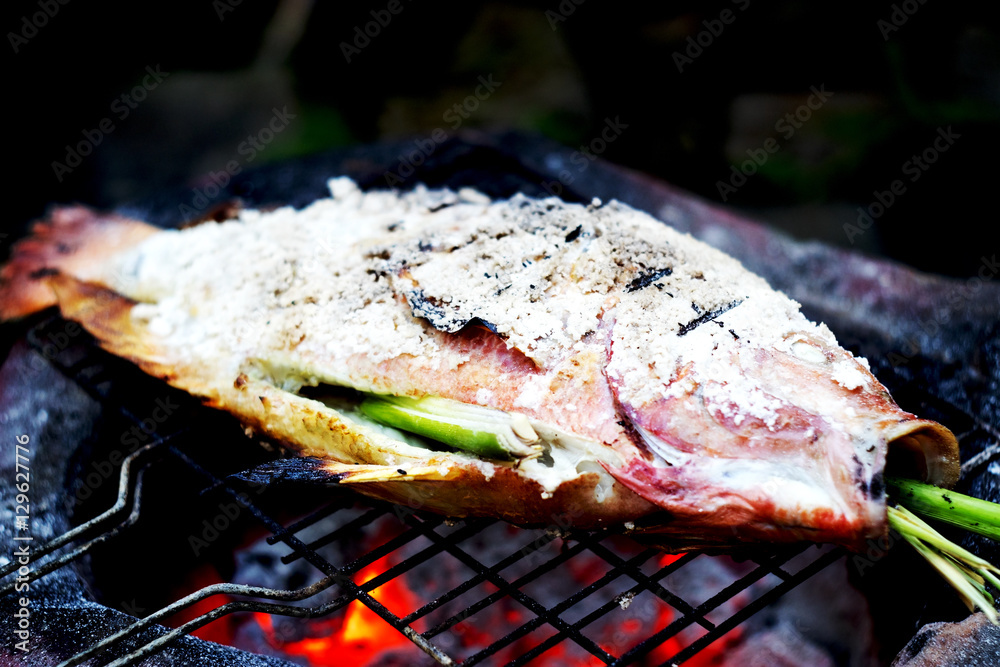 Foto de grilled fish with salt on fire do Stock | Adobe Stock