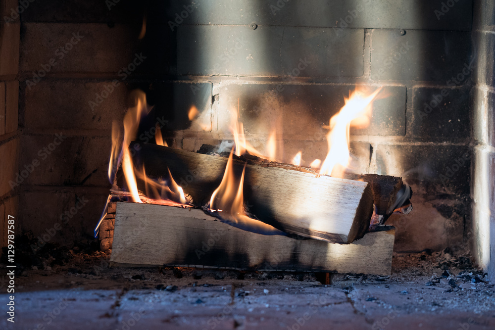 Foto Stock Firewood, brightly lit fire in the fireplace | Adobe Stock