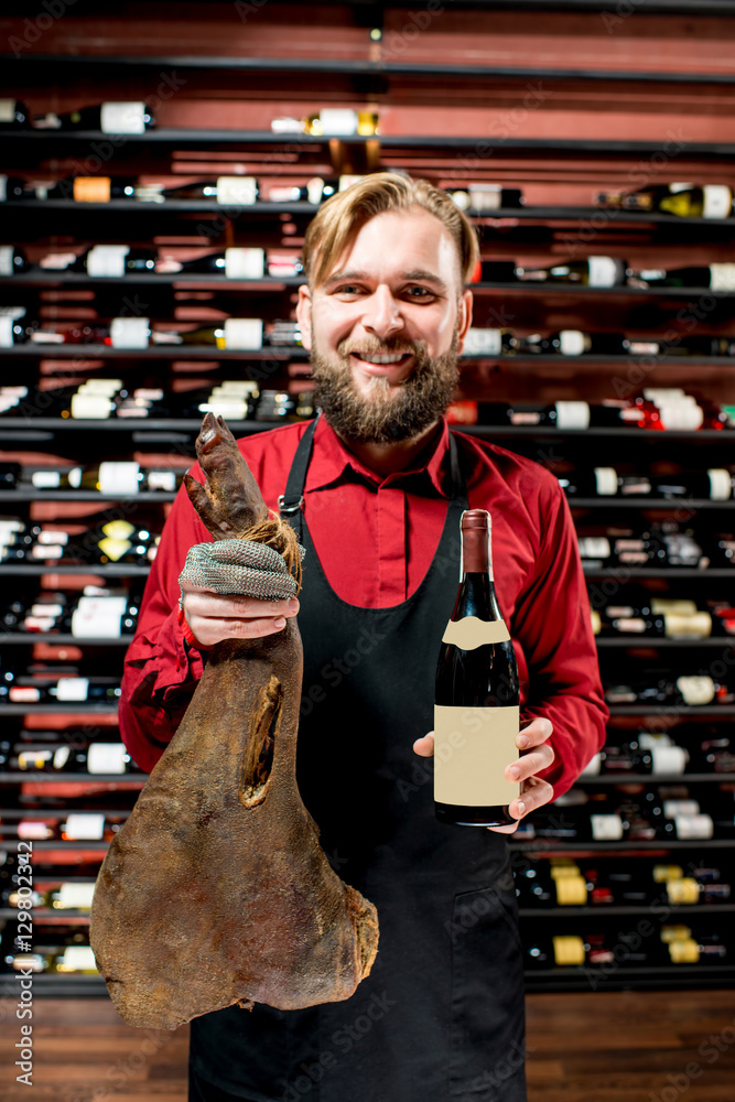 Portrait of a seller with wine bottle and jerked leg at the luxury ...