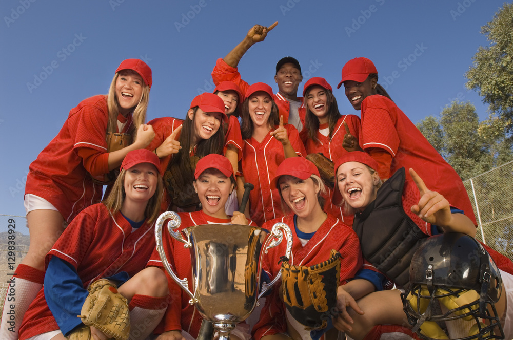 Low angle portrait of successful female softball team and coach with ...
