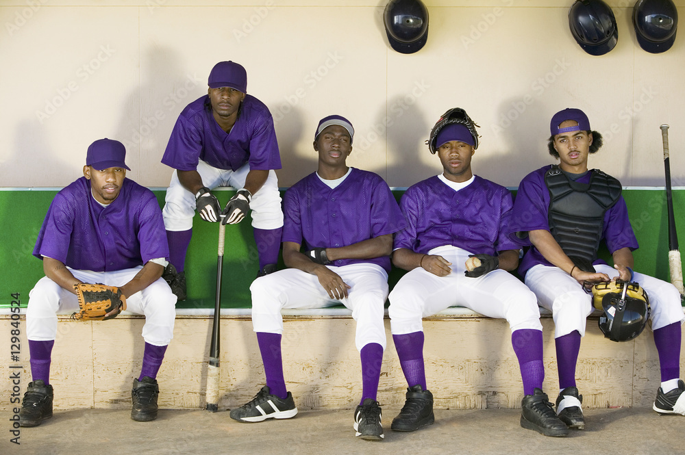 Tired baseball players sitting side by side in dugout Stock Photo ...