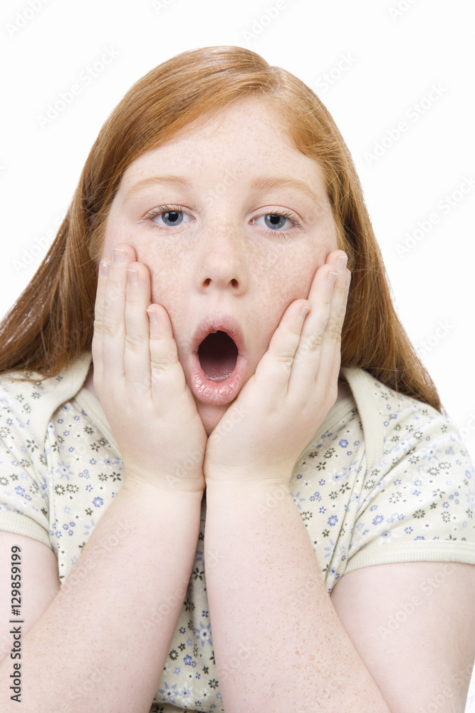 Portrait of shocked teenage girl with hands on her cheeks isolated over ...