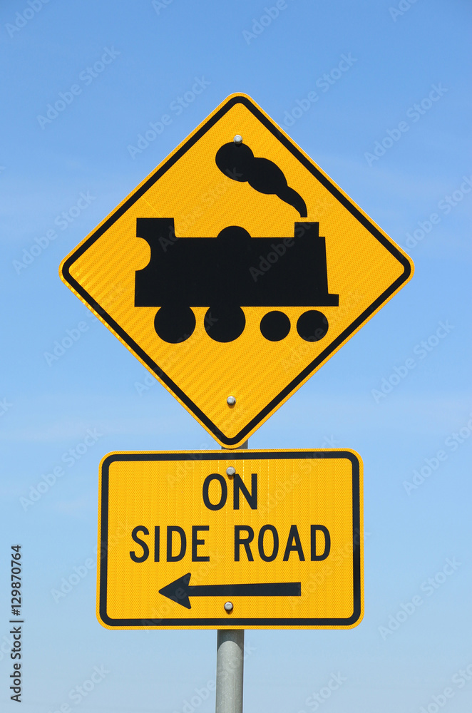 yellow and black trains on side road sign in a clear blue sky Stock ...