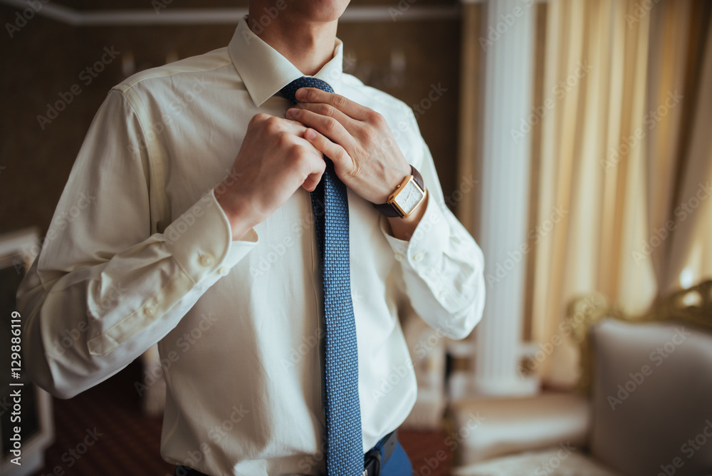 The groom adjusts his tie. Wedding preparation Stock Photo | Adobe Stock