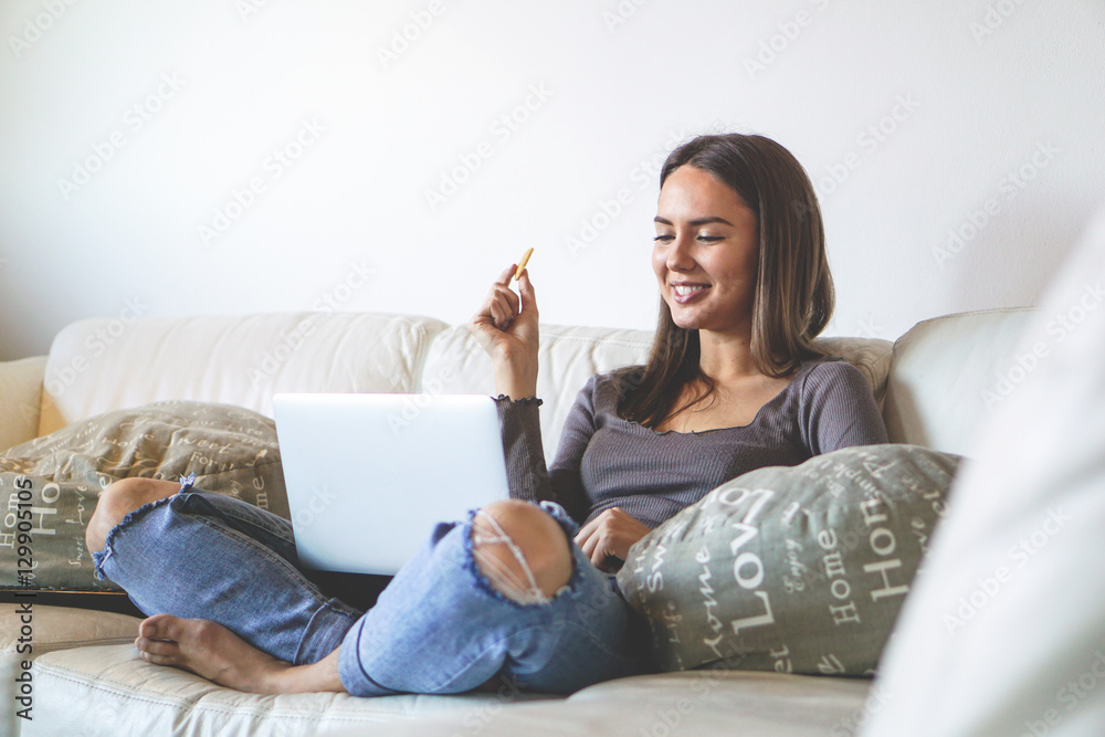 Beautiful smiling girl watching a funny movie/show on her computer ...