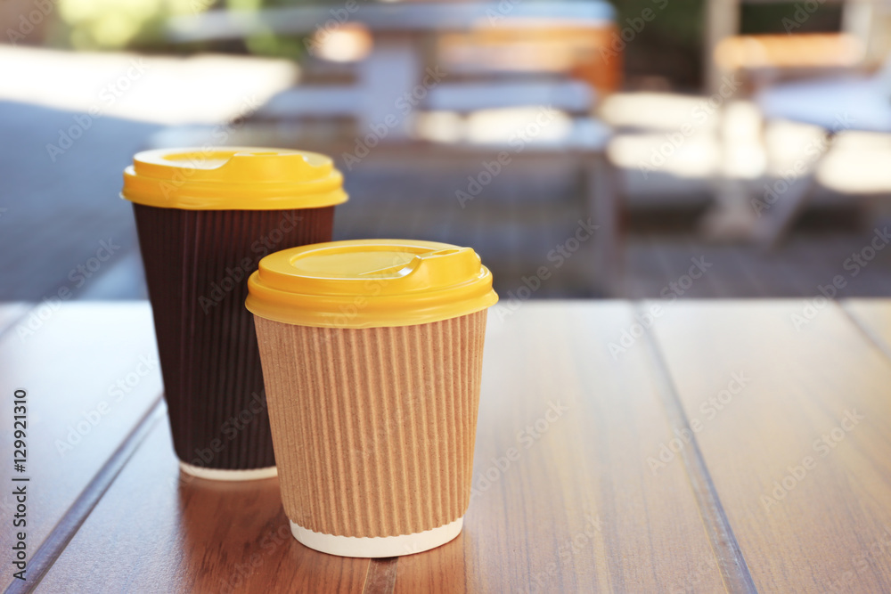 Two paper cups with tasty hot coffee on wooden table outdoors Stock ...