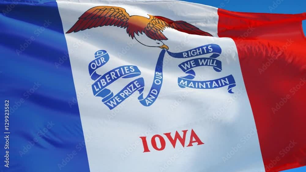 Iowa (U.S. state) flag waving in slow motion against blue sky ...