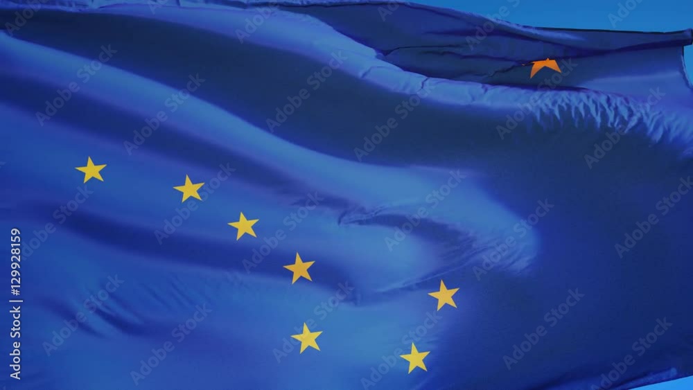 Alaska (U.S. state) flag waving in slow motion against blue sky ...