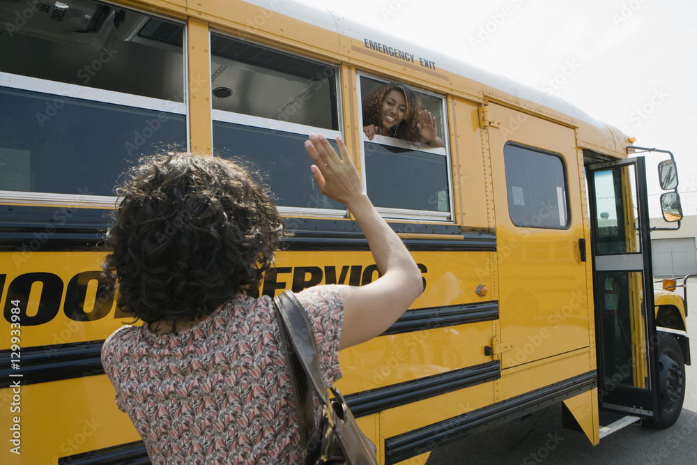 Mother waving goodbye to teenage daughter on School Bus Stock Photo ...
