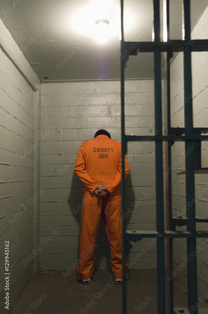 Prisoner standing against the wall in prison cell Stock Photo | Adobe Stock