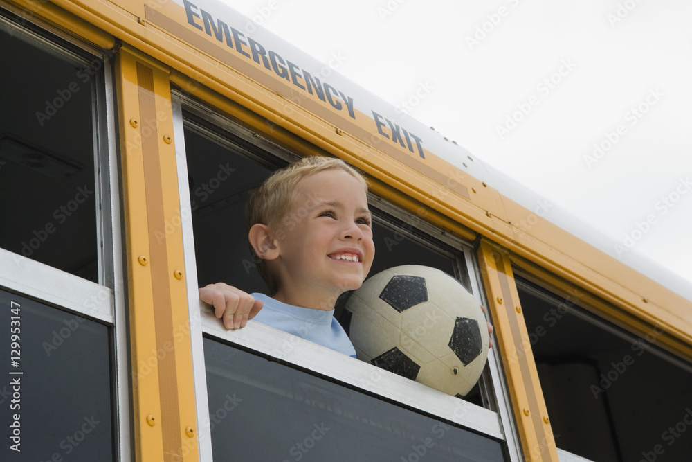 Young boy with football looking out from window of school bus Stock ...