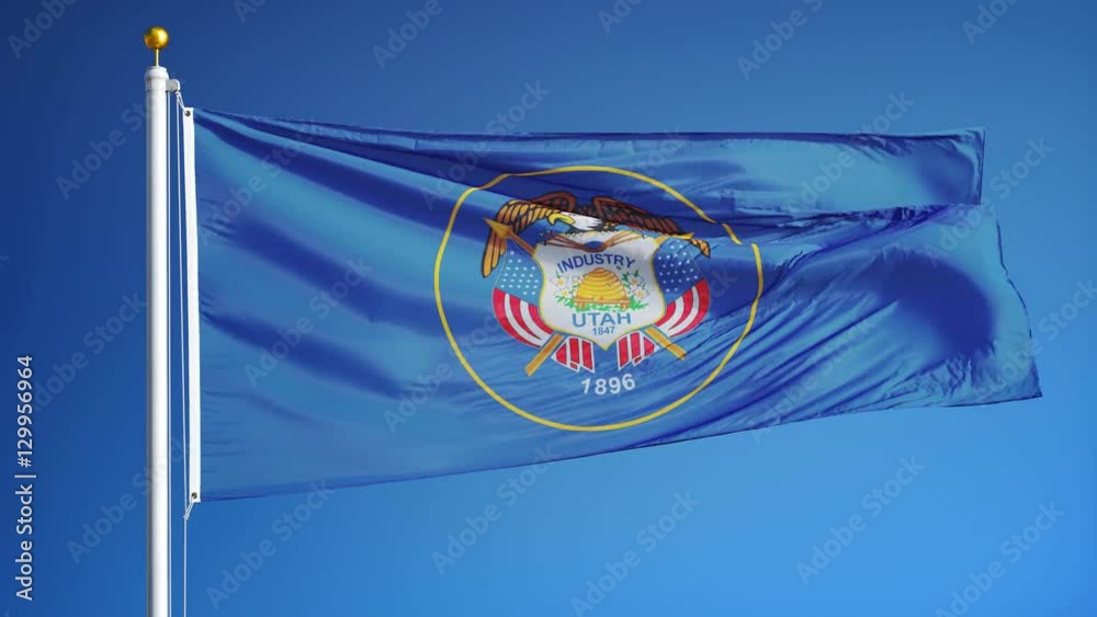 Utah (U.S. state) flag waving in slow motion against blue sky ...