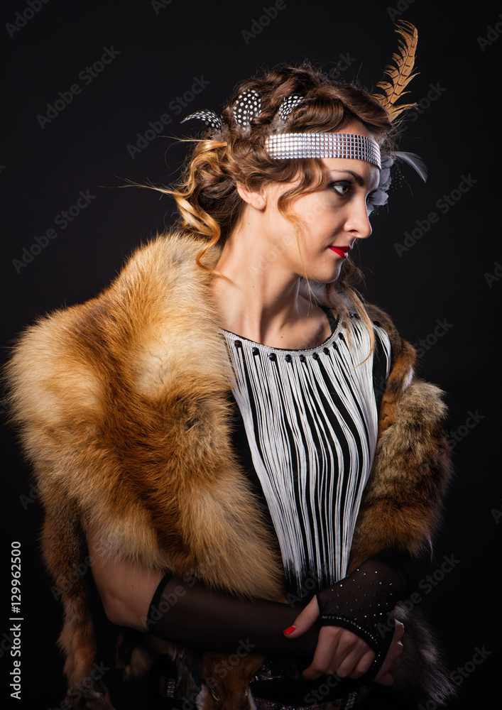 The young magnificent woman in a skin from fox and feather in hairstyle ...
