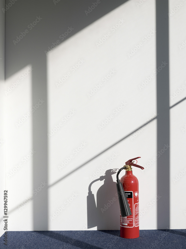 View of a fire extinguisher casting shadow on wall Stock Photo | Adobe ...