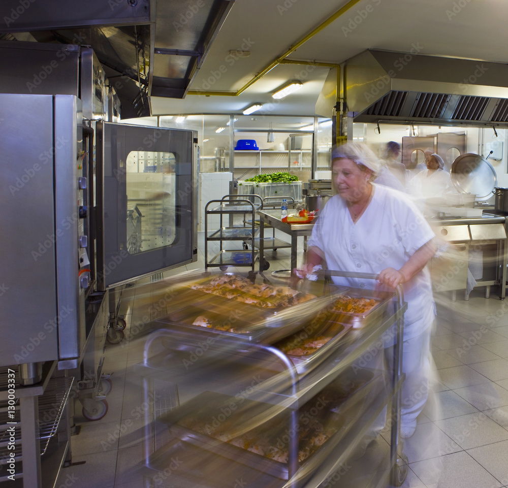 Female kitchen porter pushes a trolley of pastries Stock Photo | Adobe ...