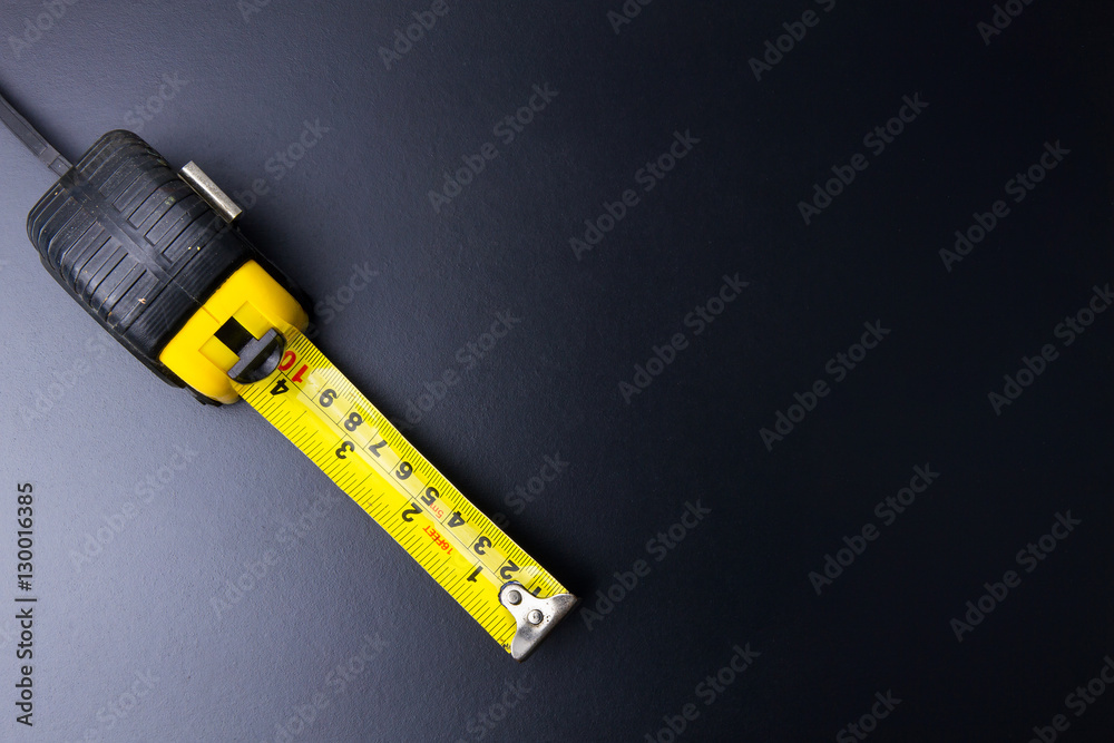 Measuring Tape construction tools on a black background with lig Stock ...