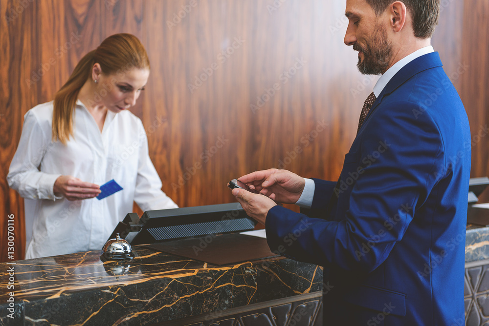 Mature man standing at check-in desk Stock Photo | Adobe Stock